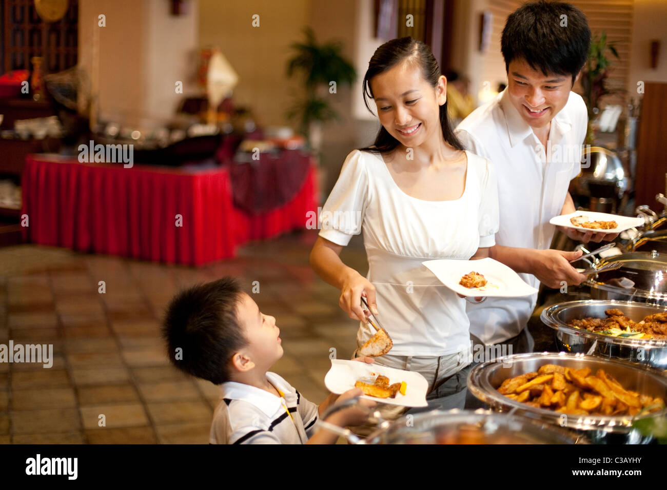 Mother helping her son at a buffet Stock Photo - Alamy