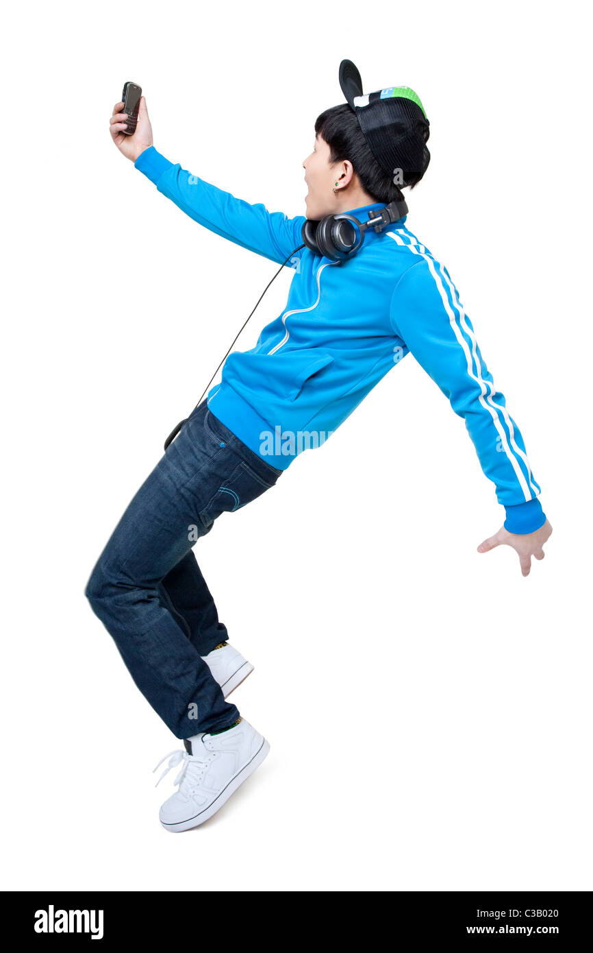 Side view of a man dancing while looking at his phone Stock Photo - Alamy