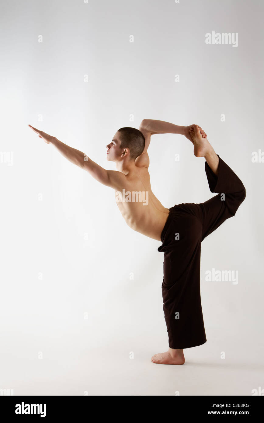 Profile of sporty guy doing physical exercise over grey background ...