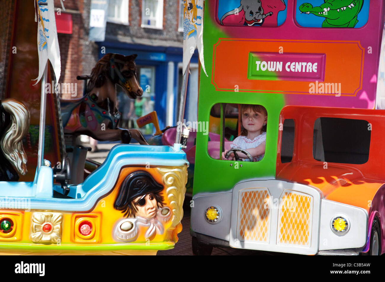 Child riding on a carousel merry go round at a fairground fair ...