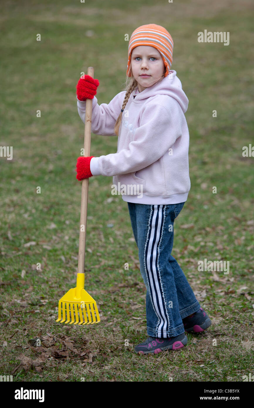 Caucasian Kid Girl Raking Leaves Stock Photo - Alamy