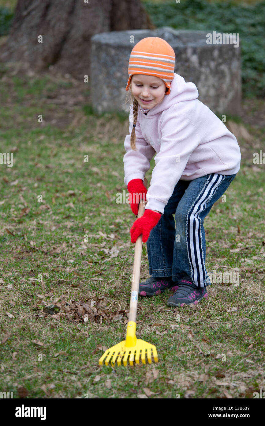 Caucasian Kid Girl Raking Leaves Stock Photo - Alamy