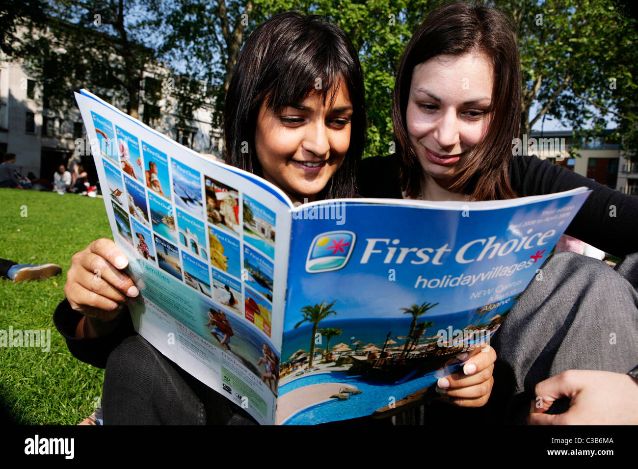 Two women looking through a First Choice Holiday Villages brochure ...