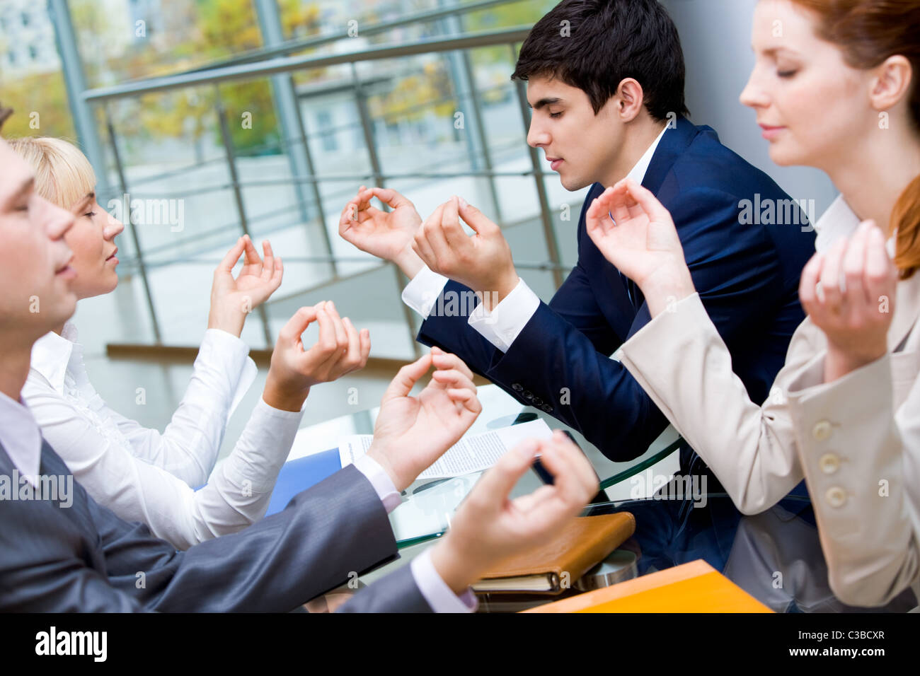 Image of concentrated business people meditating together at meeting ...