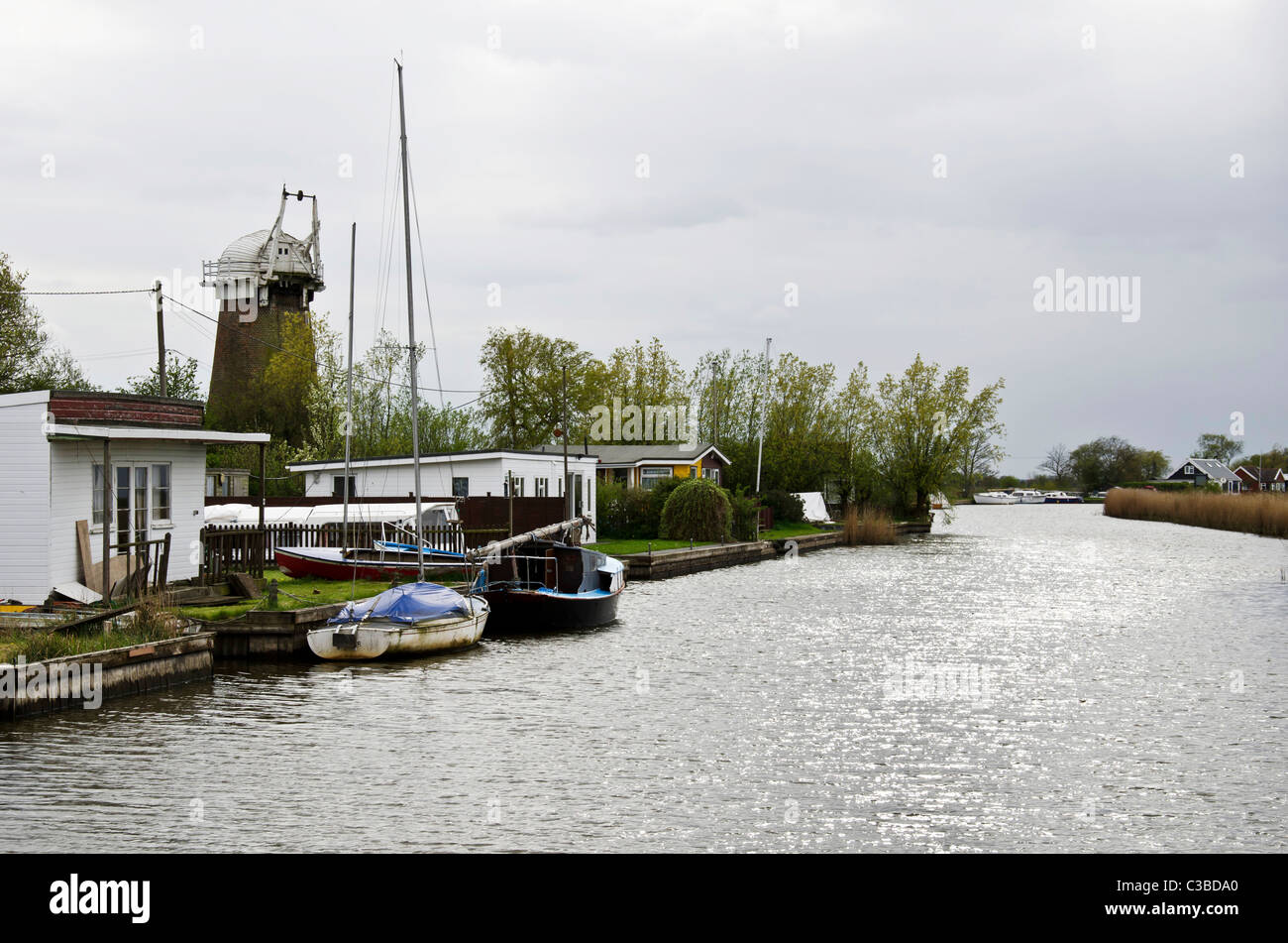 Houses and old wind pump (windmill) on the River Thurne, Norfolk Broads ...