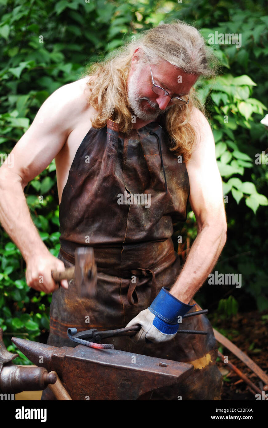 Blacksmith doing iron work to build a sword in Medieval Festival on ...