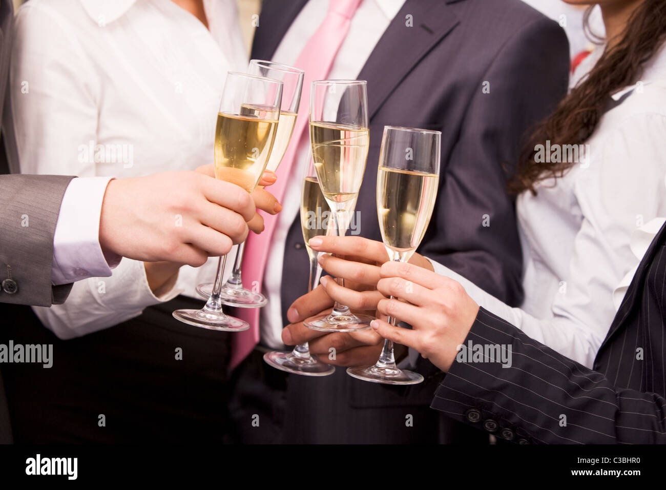 Hands holding toasting champagne flutes hi-res stock photography and ...