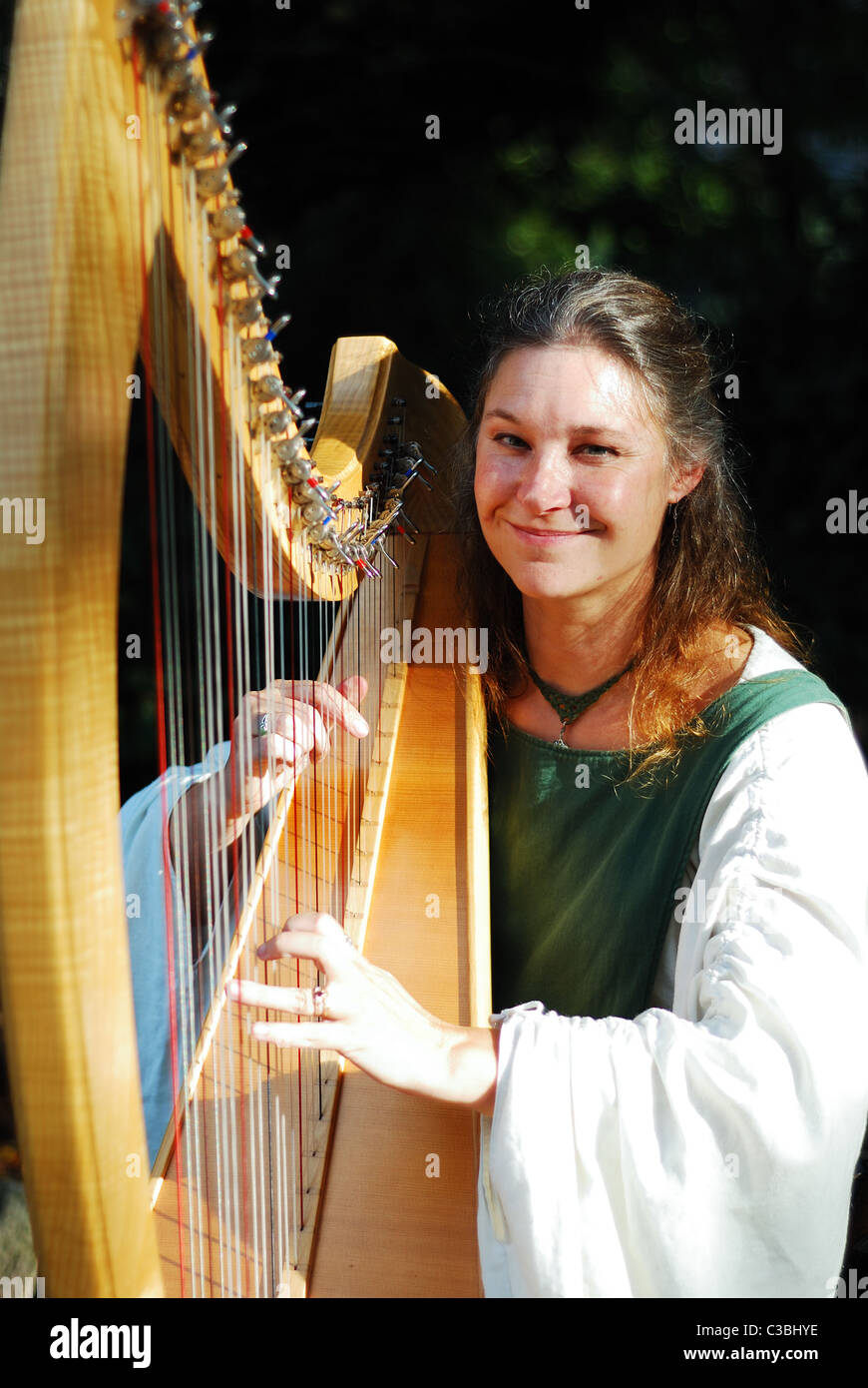 Beautiful woman musician playing harp in New York Medieval Festival ...