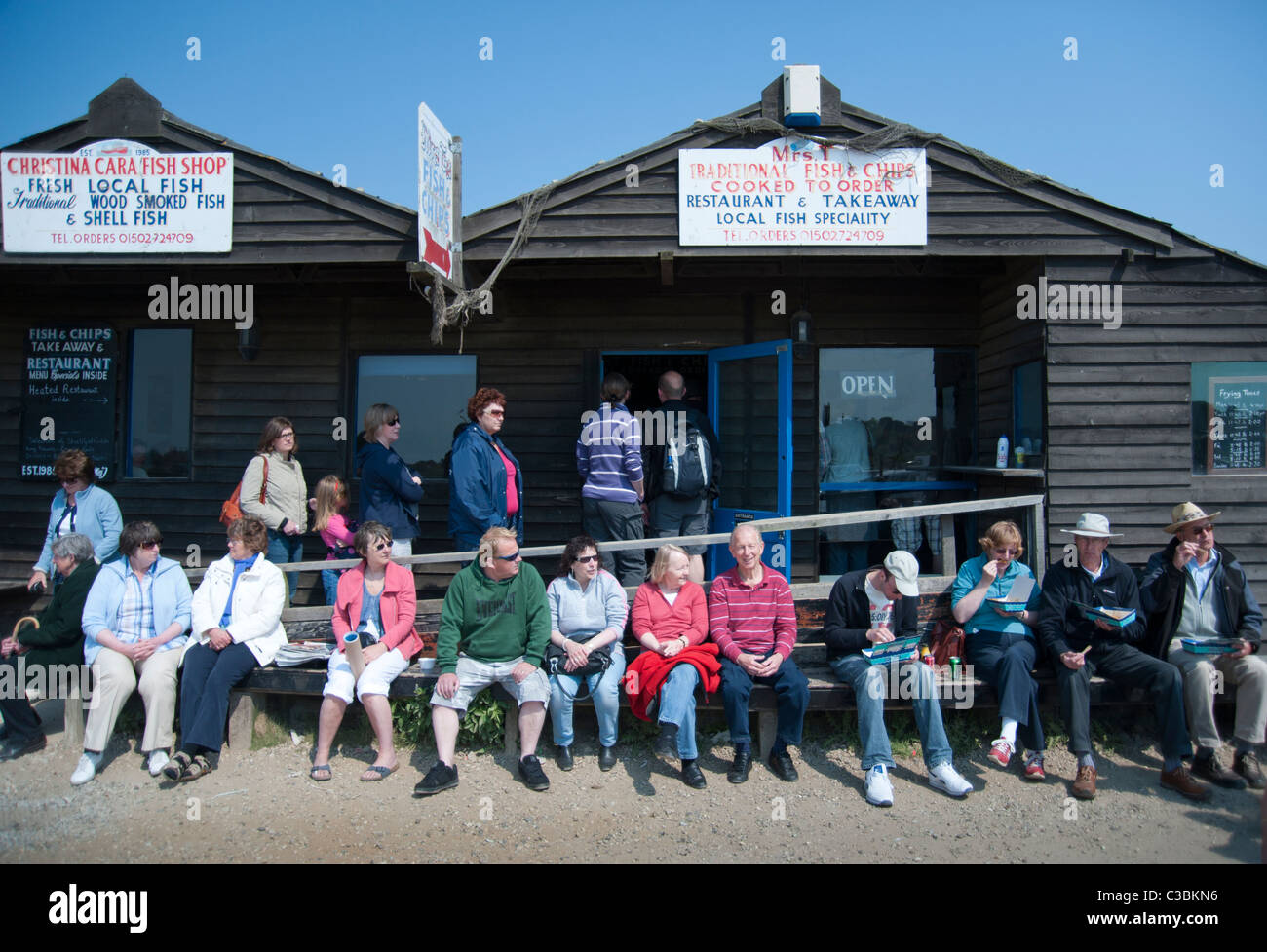 Queues of people outside fish and chip shop at Southwold harbour ...