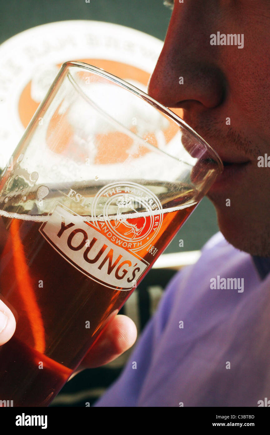 A person drinking a pint of beer at a Young & Co's Brewery Stock Photo ...