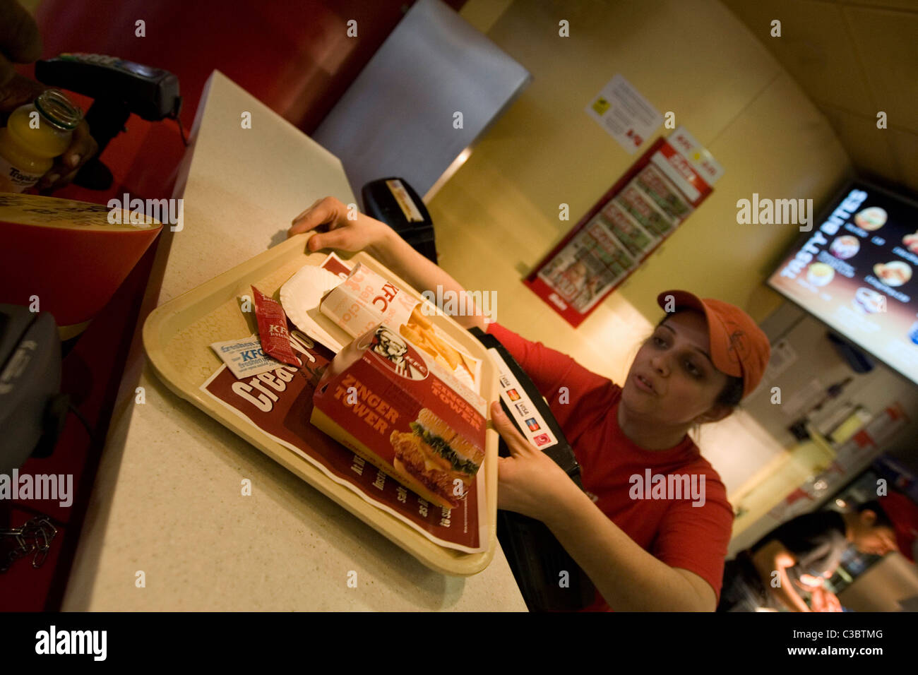 A KFC employee serving a hungry customer in the restaurant on Oxford ...