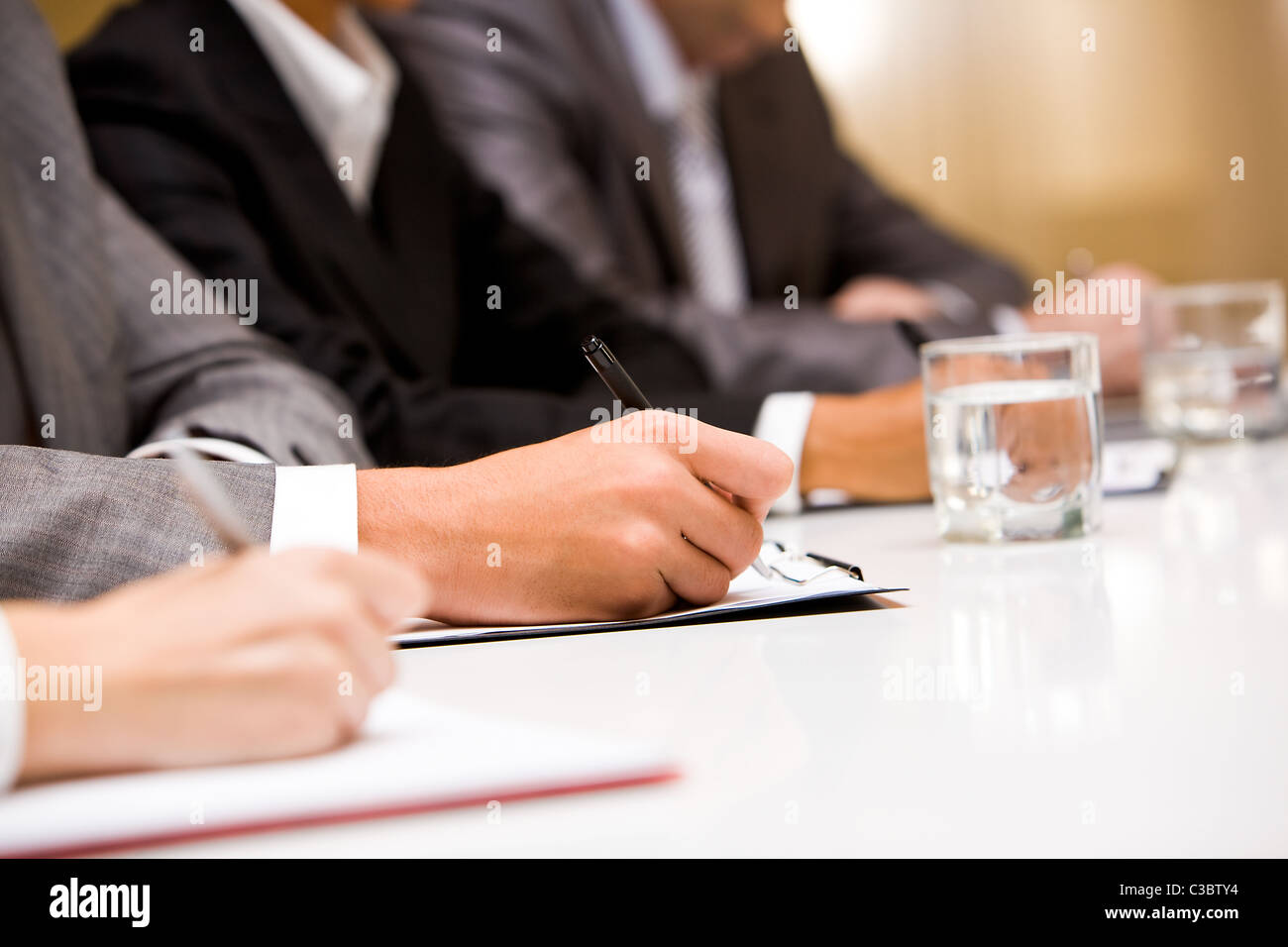 Close-up of hands with pens making notes during conference Stock Photo ...