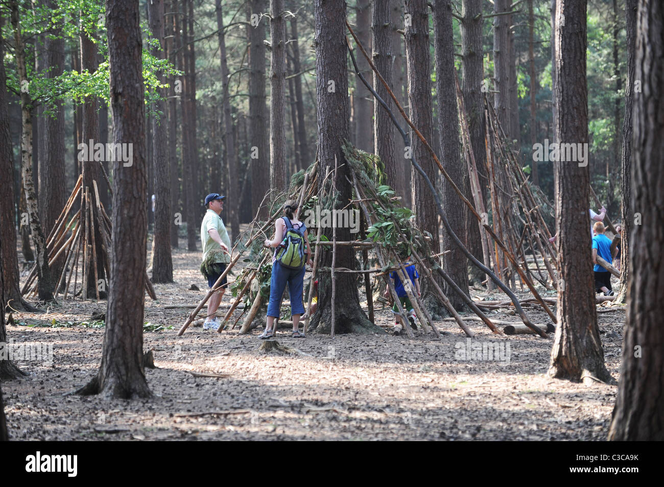 Families building wigwam-type huts built out of sticks in Swinley ...