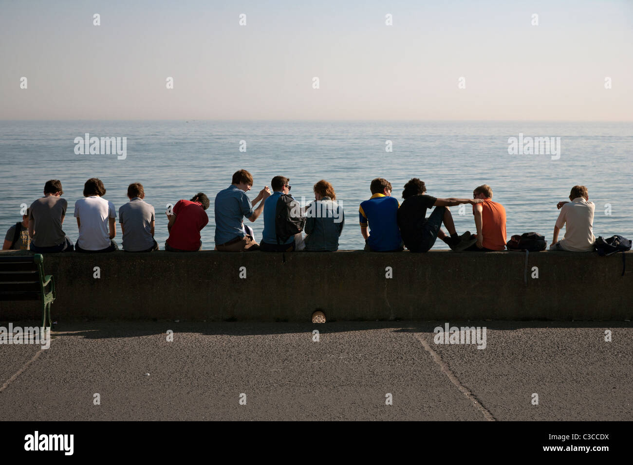 friends on a wall in brighton england Stock Photo - Alamy