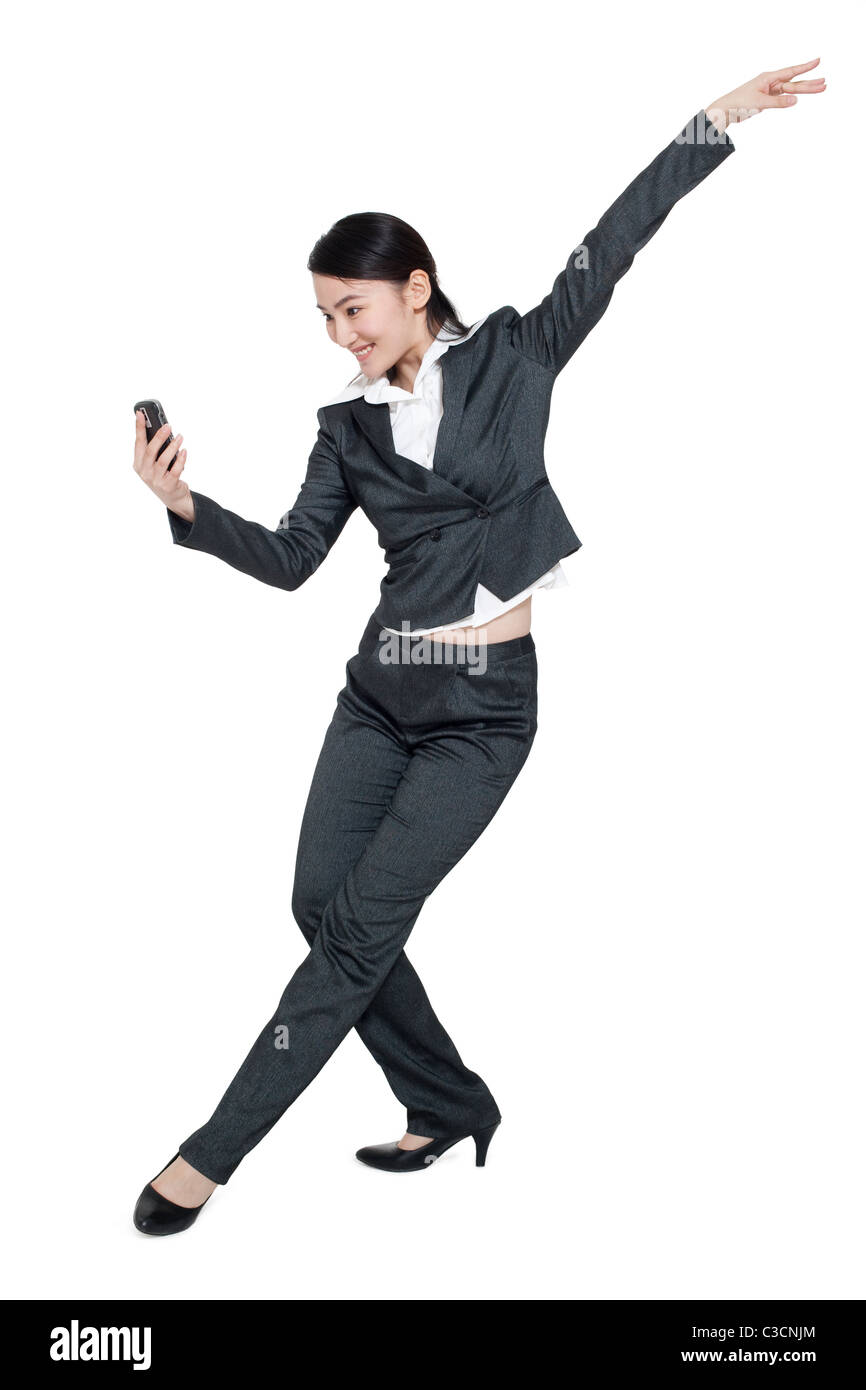 A dancing businesswoman holding a mobile phone Stock Photo - Alamy