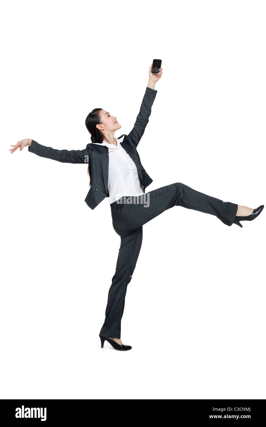 A dancing businesswoman holding a mobile phone Stock Photo - Alamy