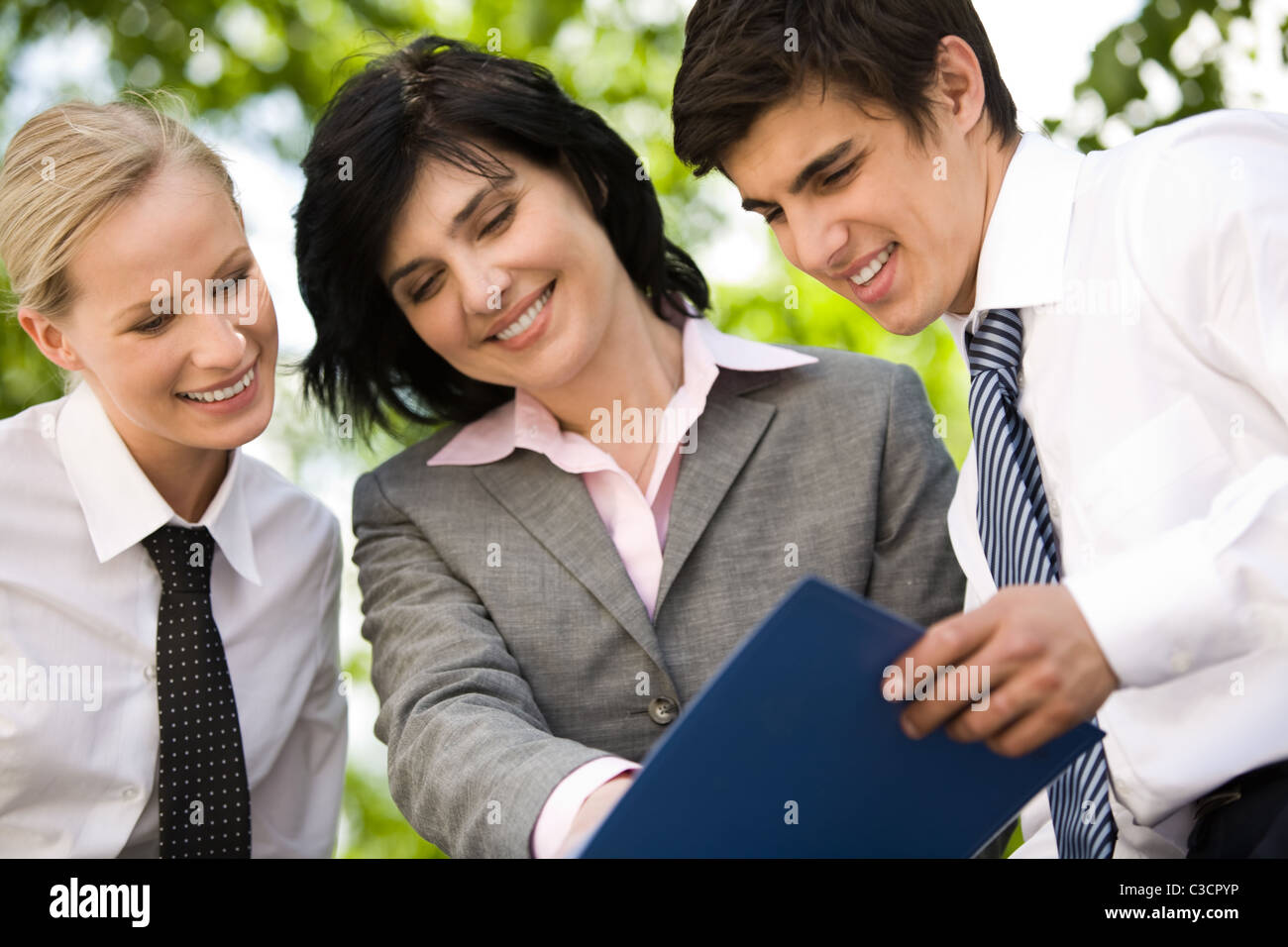 Portrait of busy people planning their work together outside at summer ...