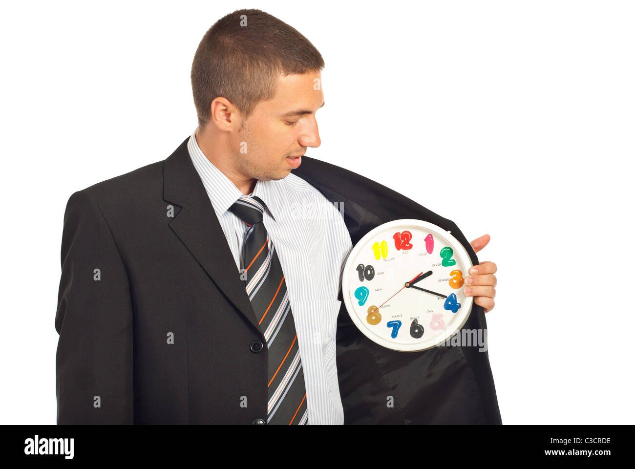 Business man checking the time and holding a clock in interior of ...