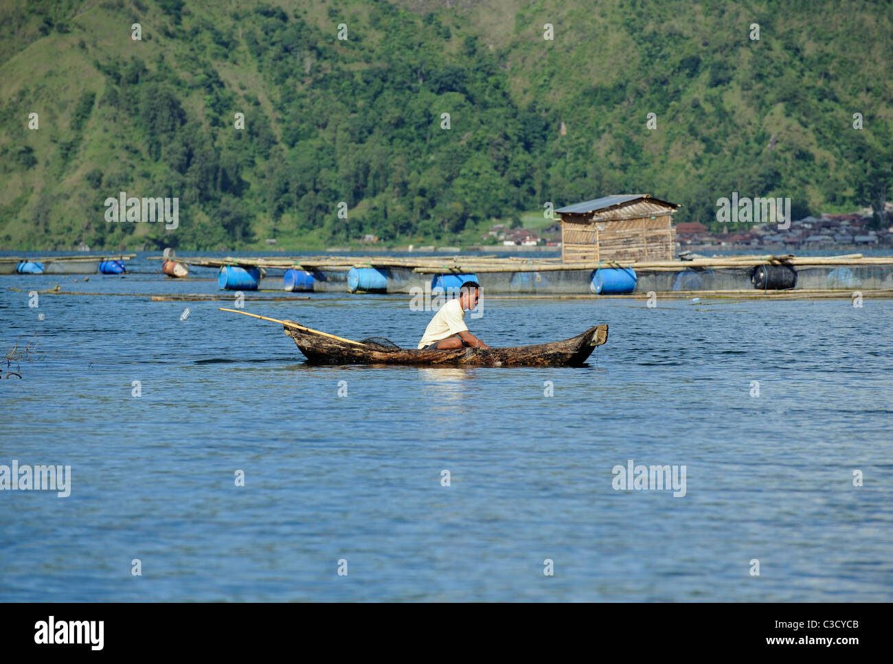 a fisherman using a traditional wooden dugout canoe, lake batur, bali ...