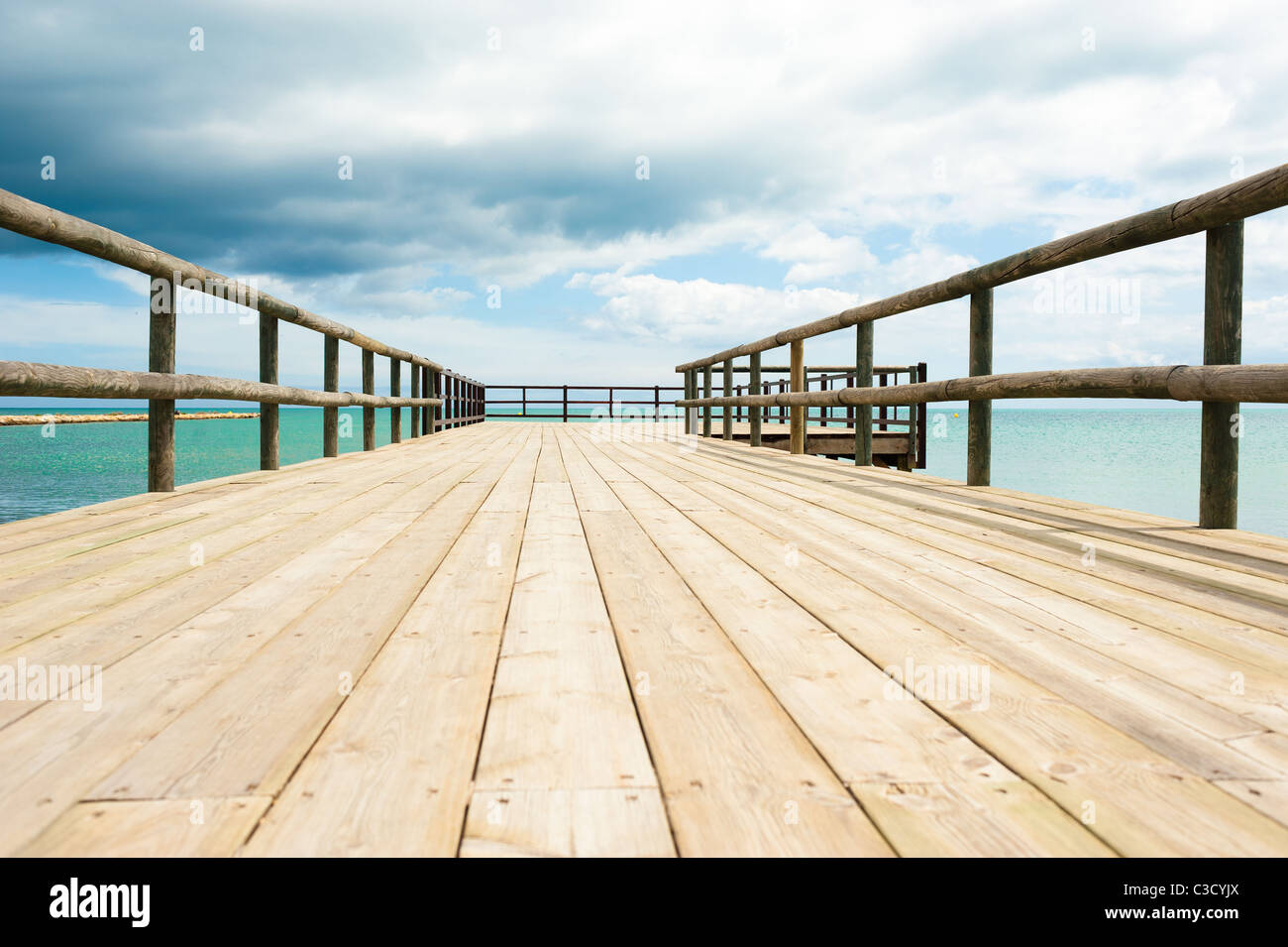 Traditional wooden footbridge facing a dramatic ocean setting Stock ...