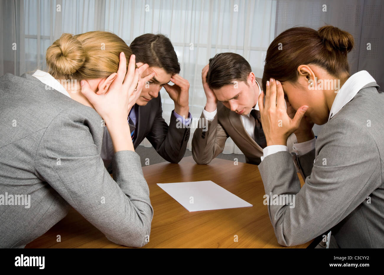 Portrait of business people sitting around table and touching their ...