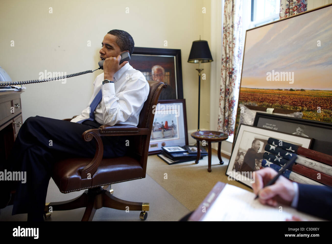 US President Barack Obama takes a phone call in his private study off ...
