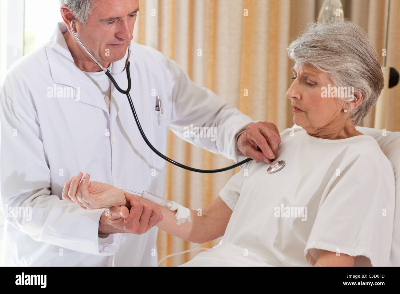 Senior doctor taking the heartbeat of his patient Stock Photo - Alamy