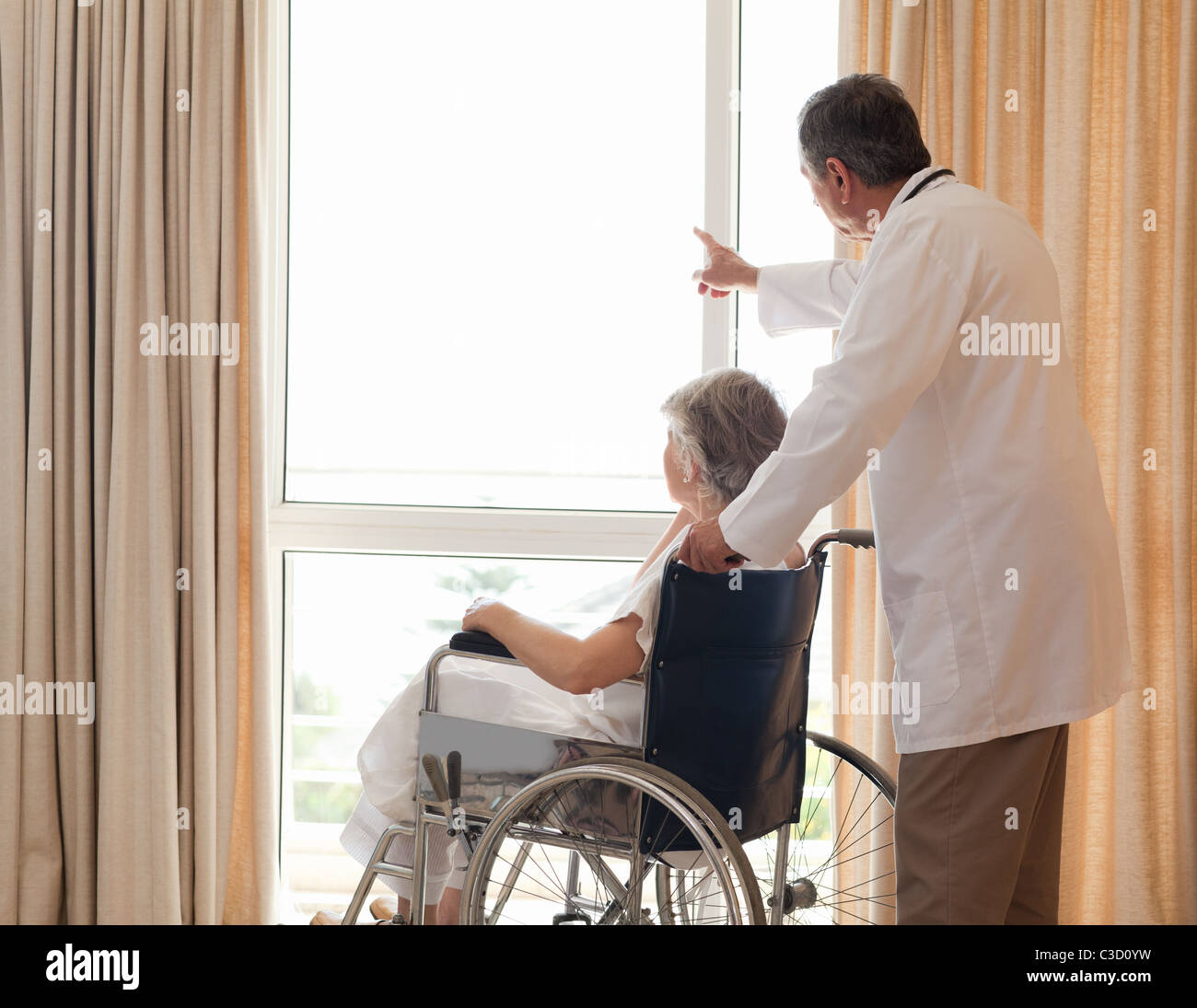 Doctor with his patient looking out the window Stock Photo - Alamy