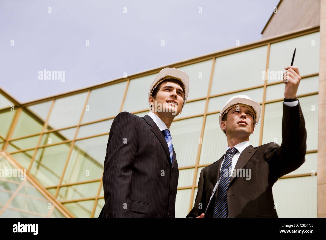 Photo of serious employee pointing at something with confident foreman ...
