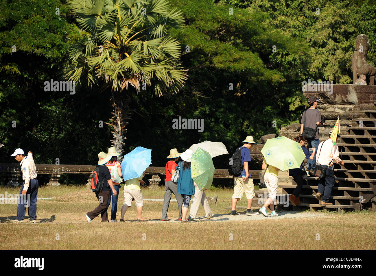 Visitors and tourists in the grounds of Angkor Wat temple about to go ...