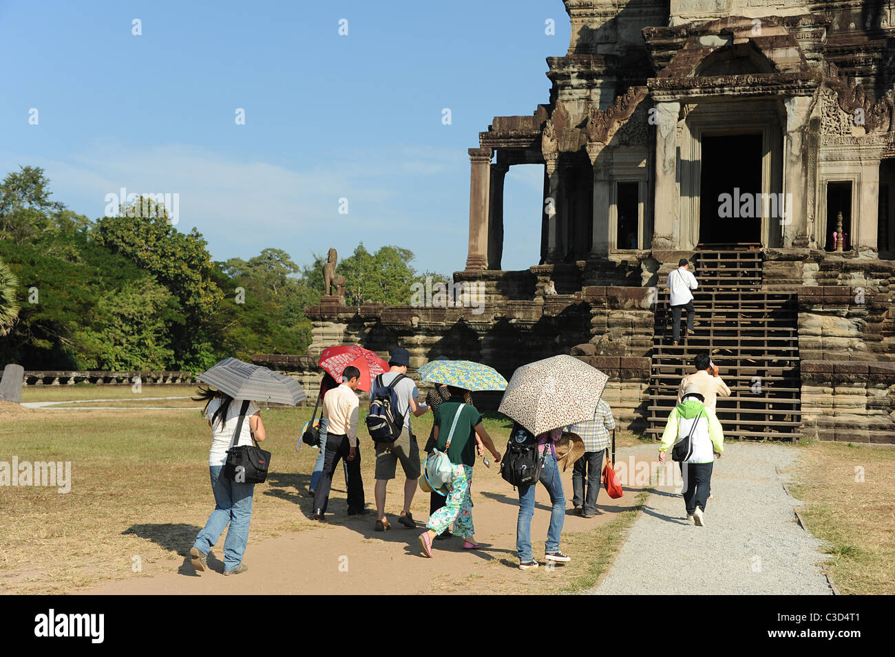 Visitors and tourists in the grounds of Angkor Wat temple about to go ...
