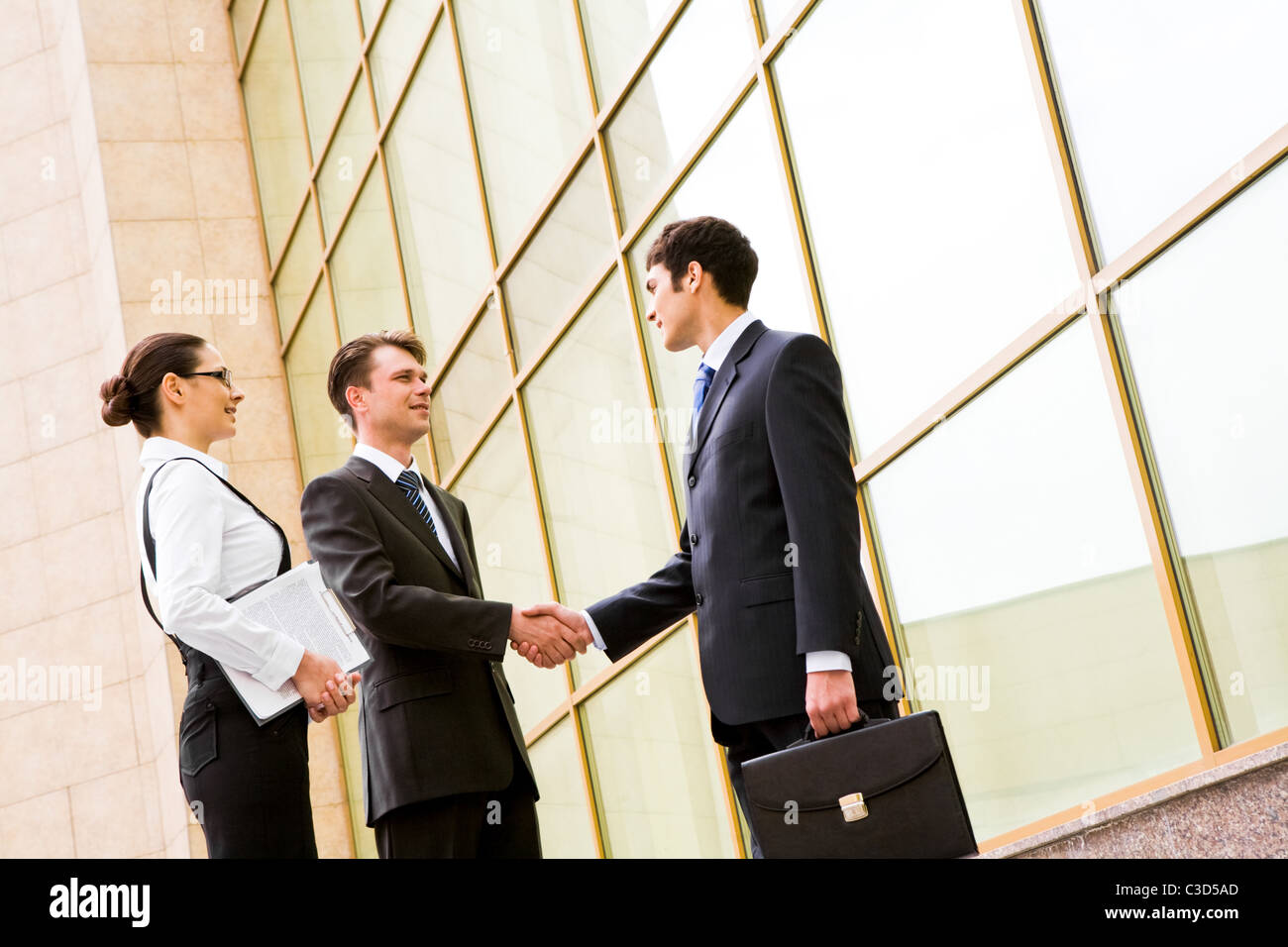 Portrait of successful partners handshaking after making agreement with ...