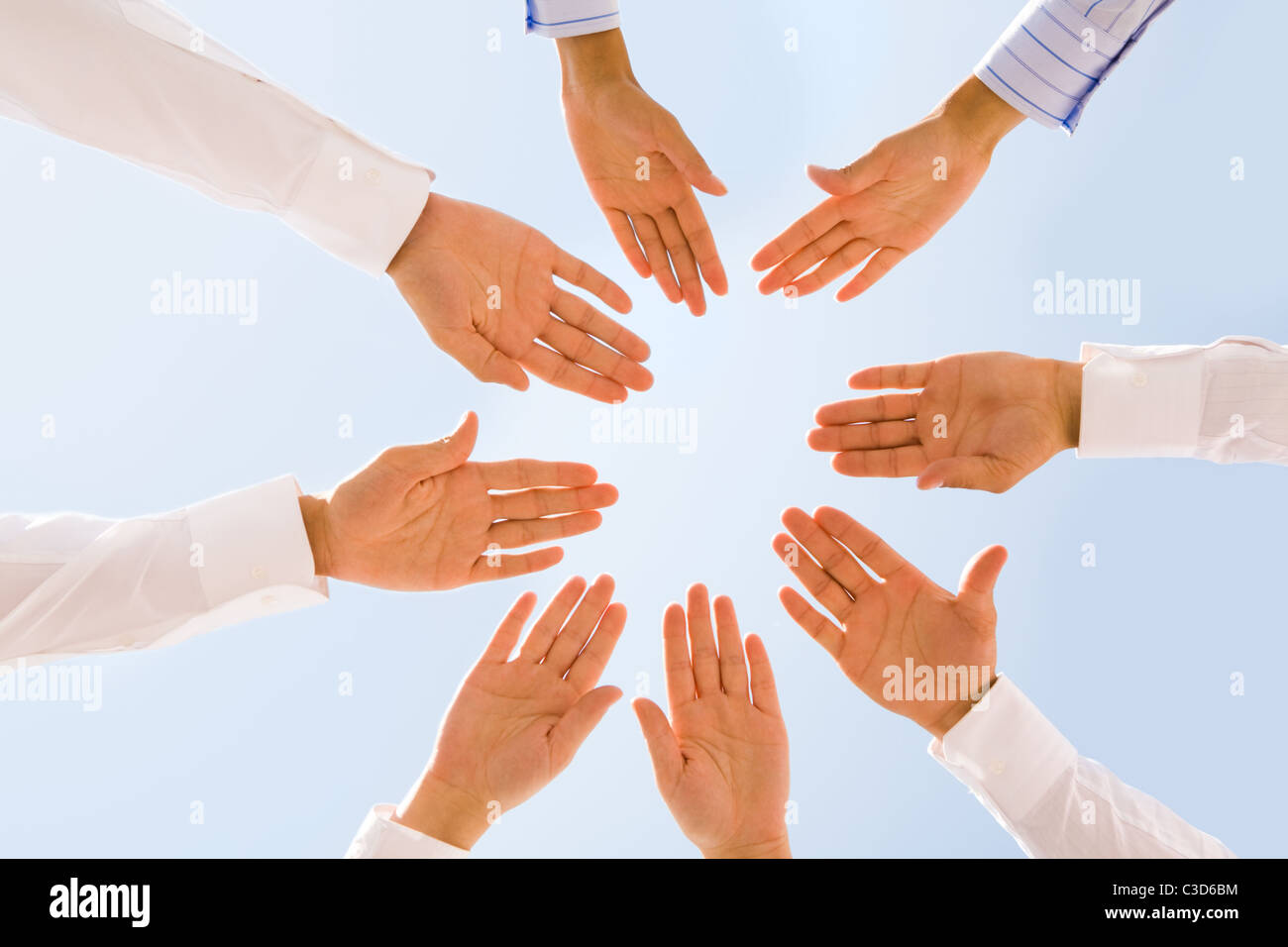 Below angle of circle of people hands with blue sky above Stock Photo ...