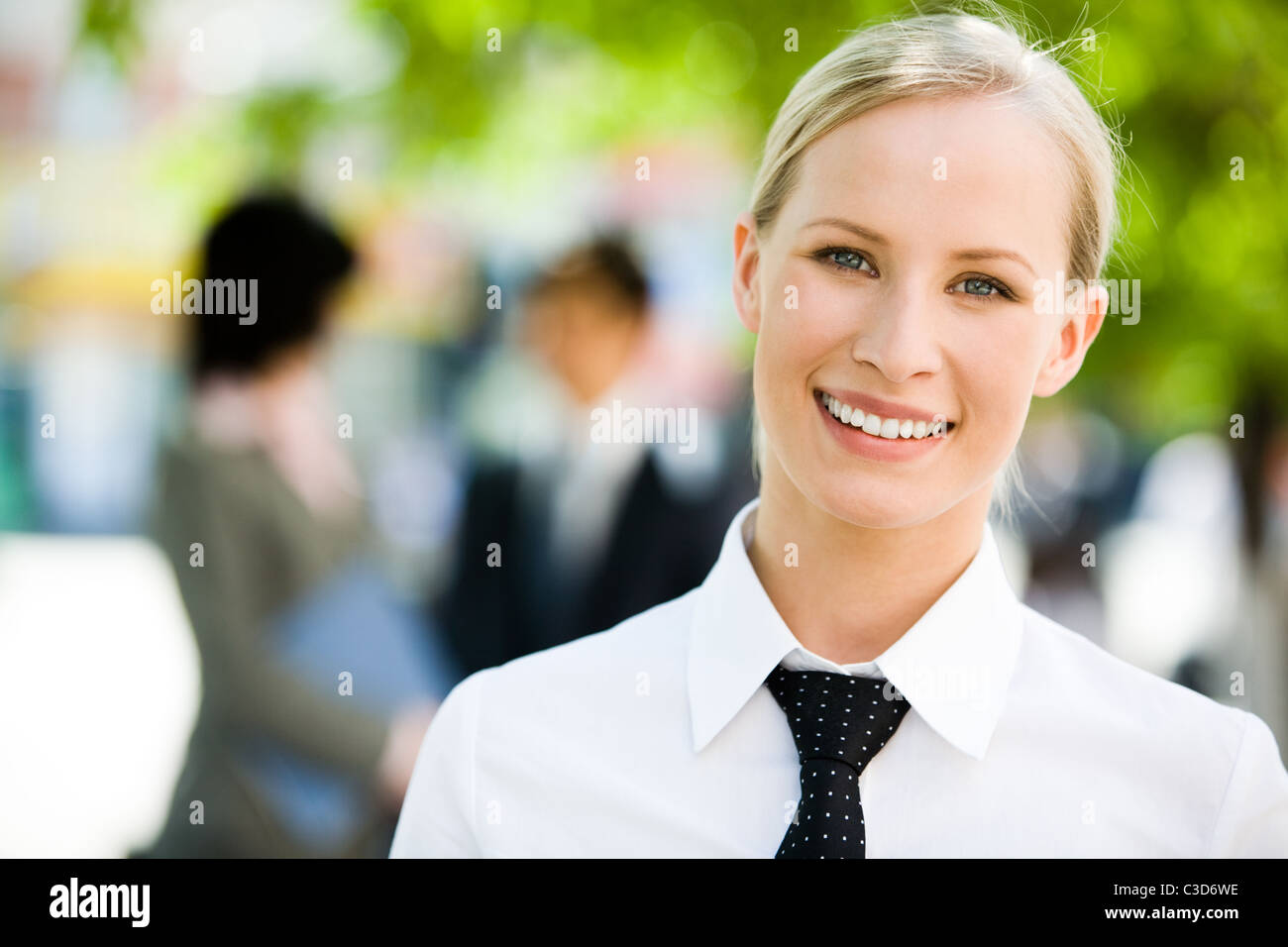 Portrait of pretty employee smiling at camera in a natural environment ...