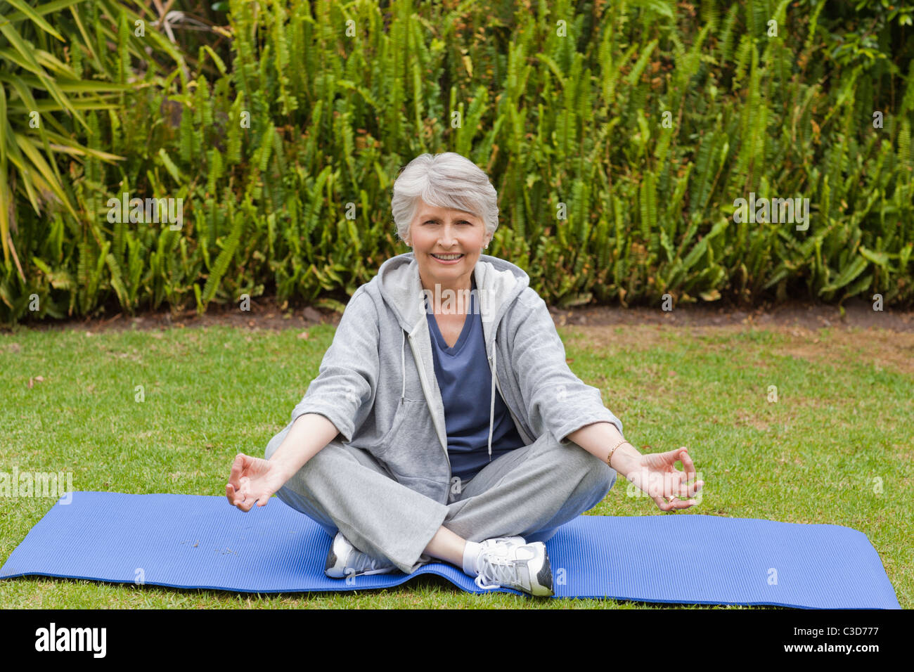 Retired woman practicing yoga in the garden Stock Photo - Alamy