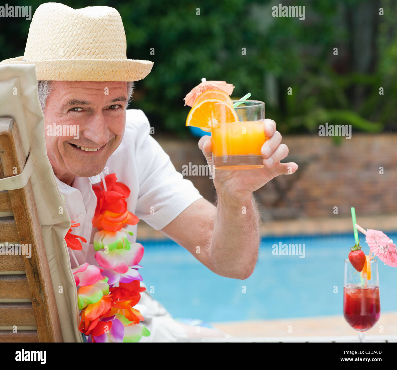 Mature man drinking a cocktail beside the swimming pool Stock Photo - Alamy