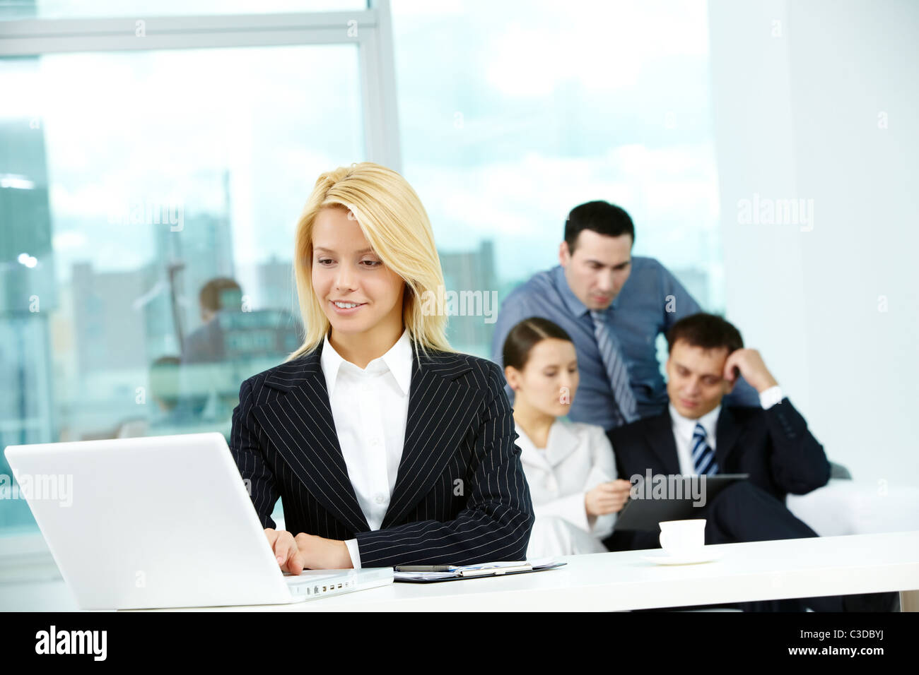 Portrait of pretty secretary looking at laptop screen in working ...