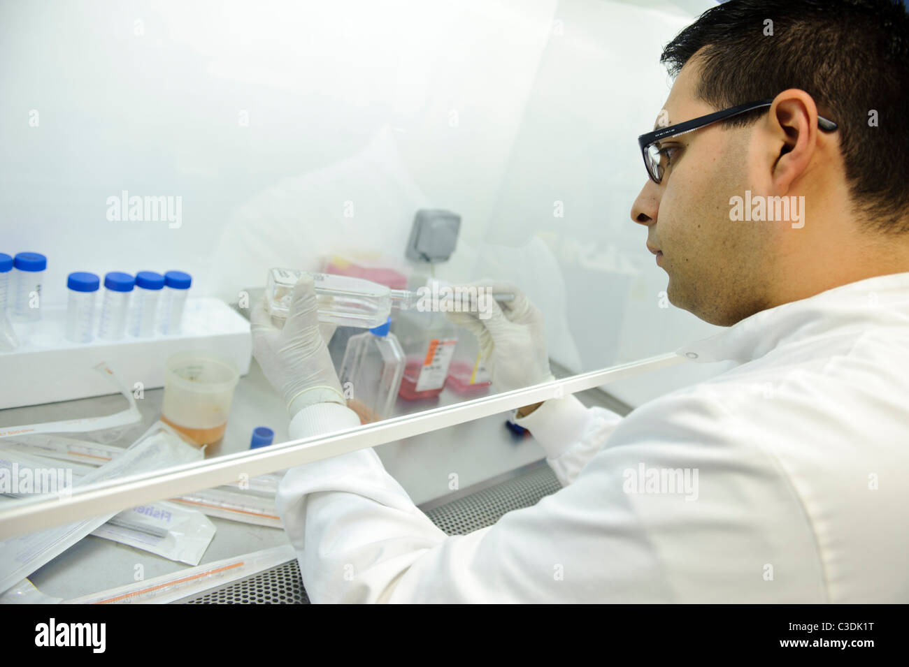 Male scientist white lab coat white gloves and glasses working at fume ...