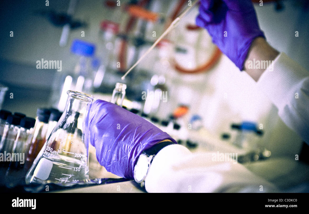 Close up of male scientist wearing white lab coat goggles and purple ...