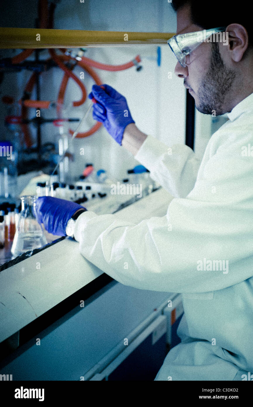Close up of male scientist wearing white lab coat goggles and purple ...