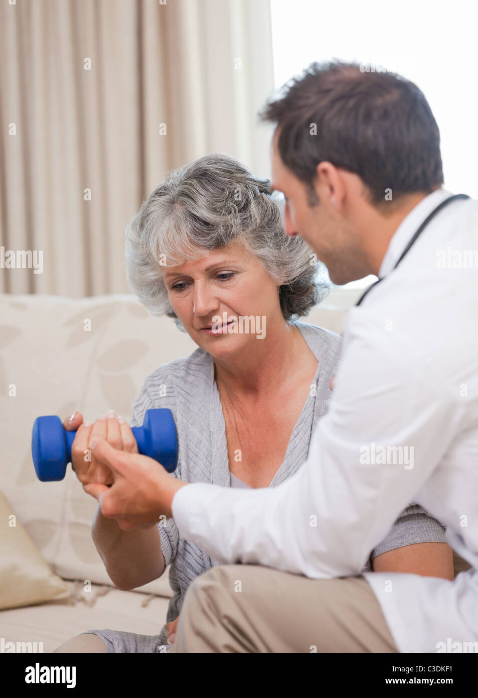 Handsome doctor helping his patient to do exercises Stock Photo - Alamy