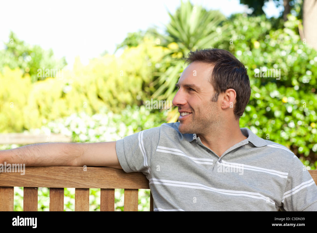 Portrait of a man sitting on a bench Stock Photo - Alamy