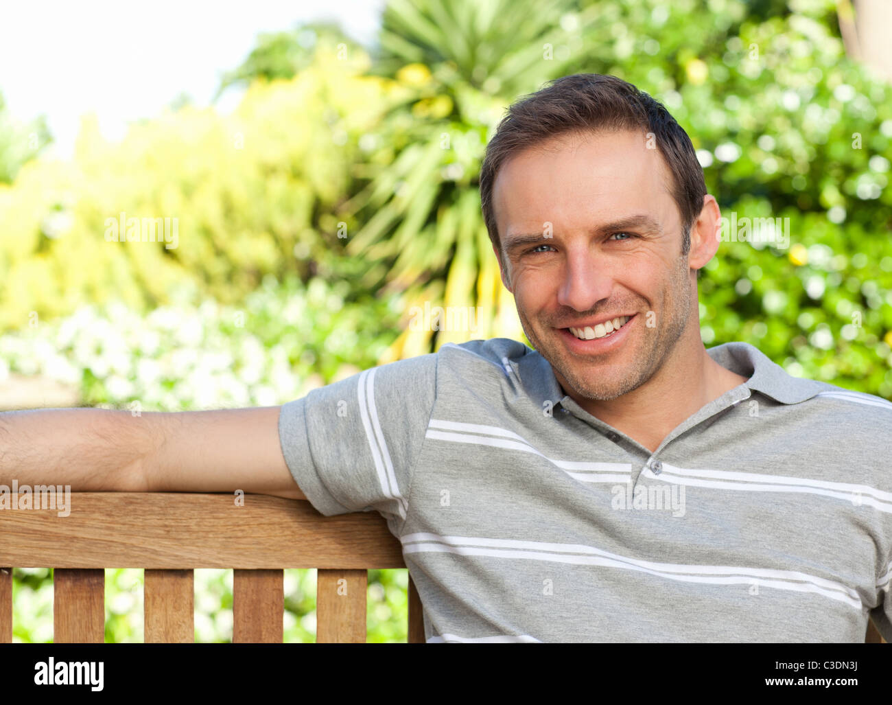 Portrait of a man sitting on a bench Stock Photo - Alamy