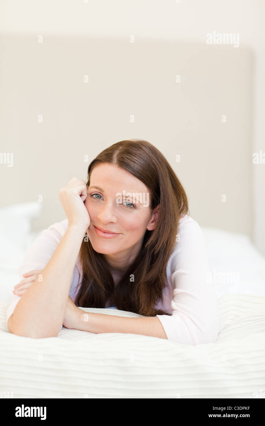 Pretty woman lying down on her bed Stock Photo - Alamy
