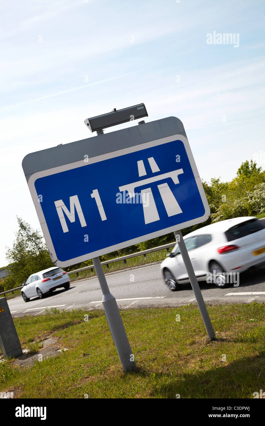 M1 Motorway sign England. Sunny day with blue sky. White cars travel ...