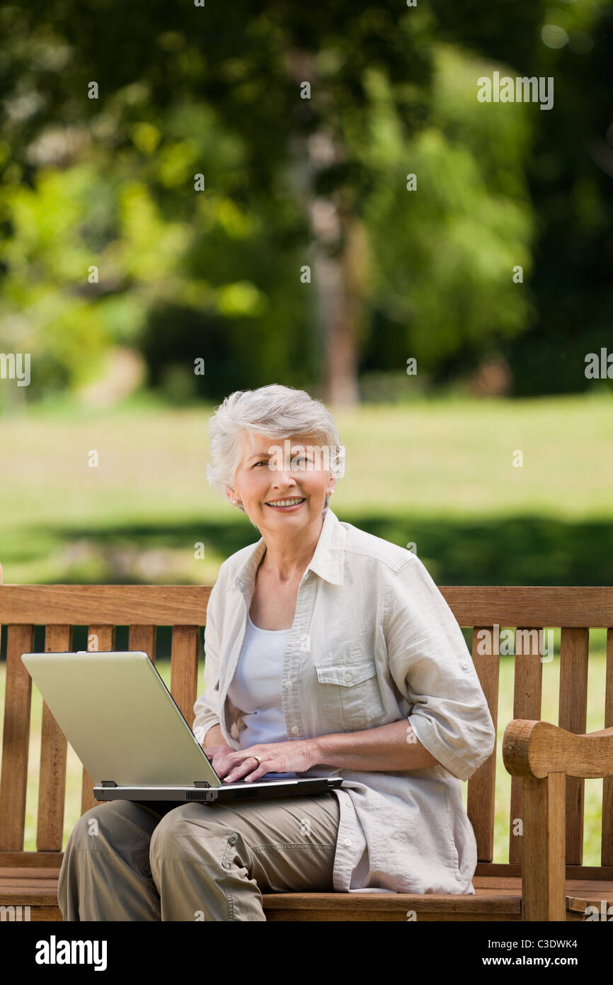 Mature woman working on her laptop on the bench Stock Photo - Alamy