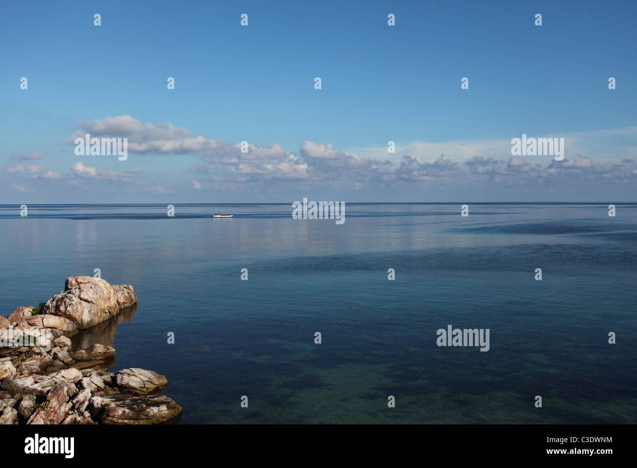 A boat passes the main island of Karimunjawa Islands, Central Java ...