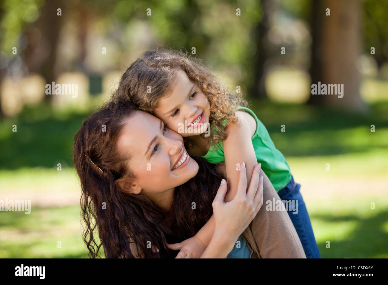 Woman hugging her daughter in the park Stock Photo - Alamy