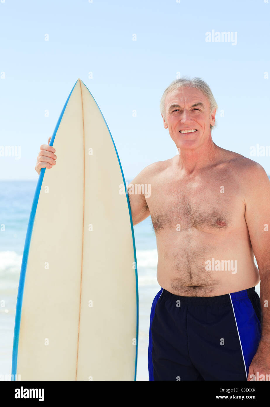 Retired man with his surfboard Stock Photo - Alamy