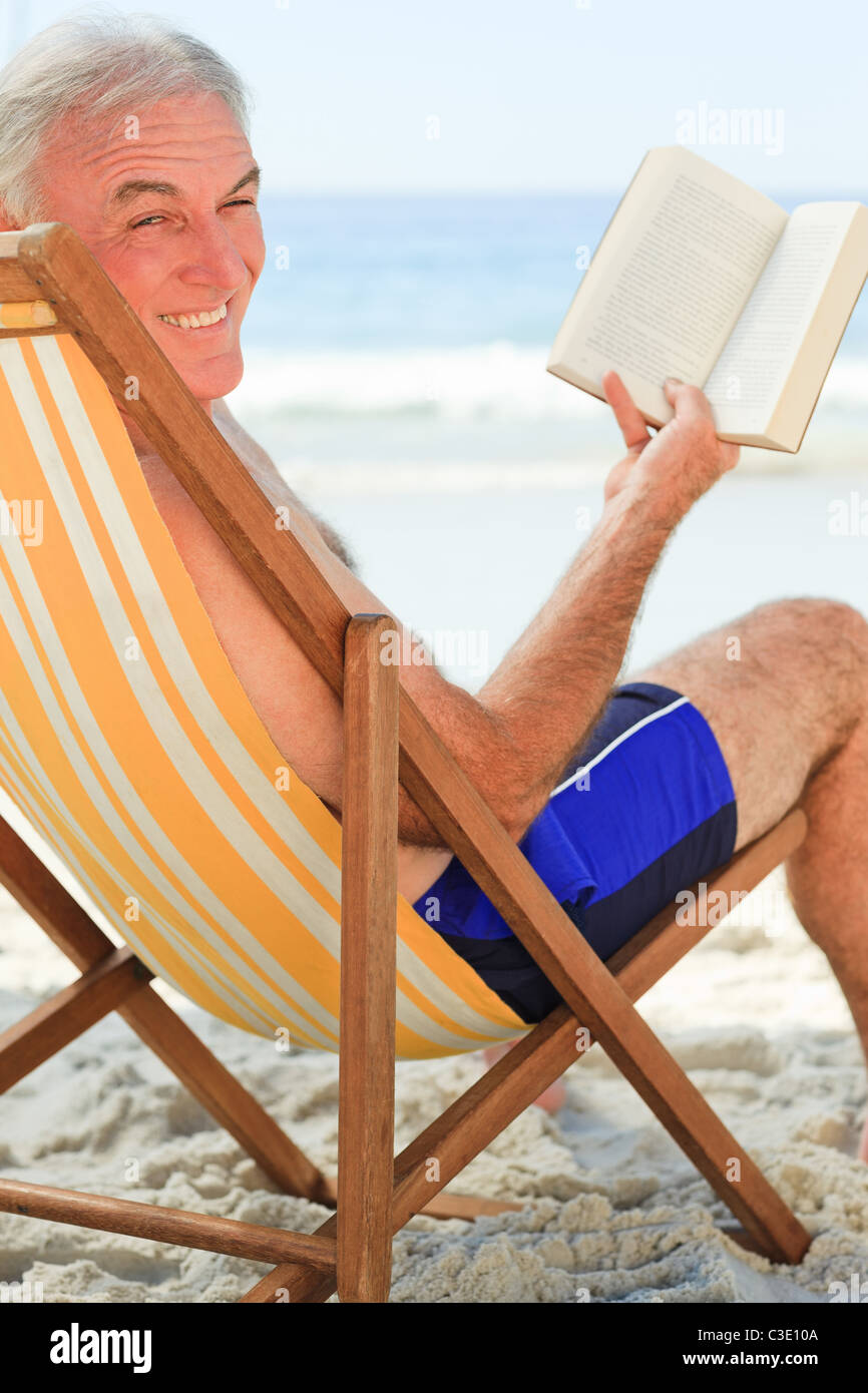Senior man reading a book at the beach Stock Photo - Alamy